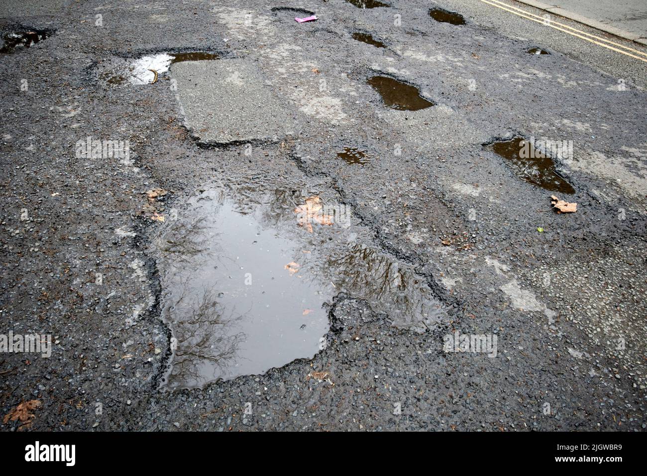 water filled potholes in the middle of a road in england uk Stock Photo ...