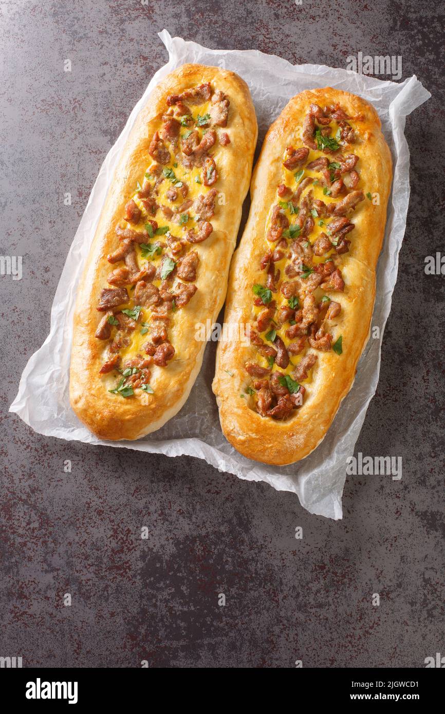 Open meat pie with egg, stuffed bread, pizza close-up on parchment on ...