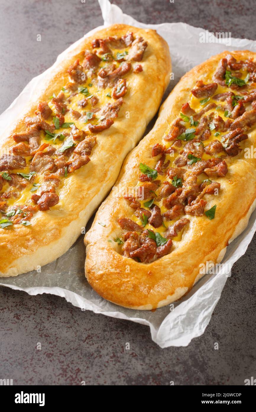 Open meat pie with egg, stuffed bread, pizza close-up on parchment on ...