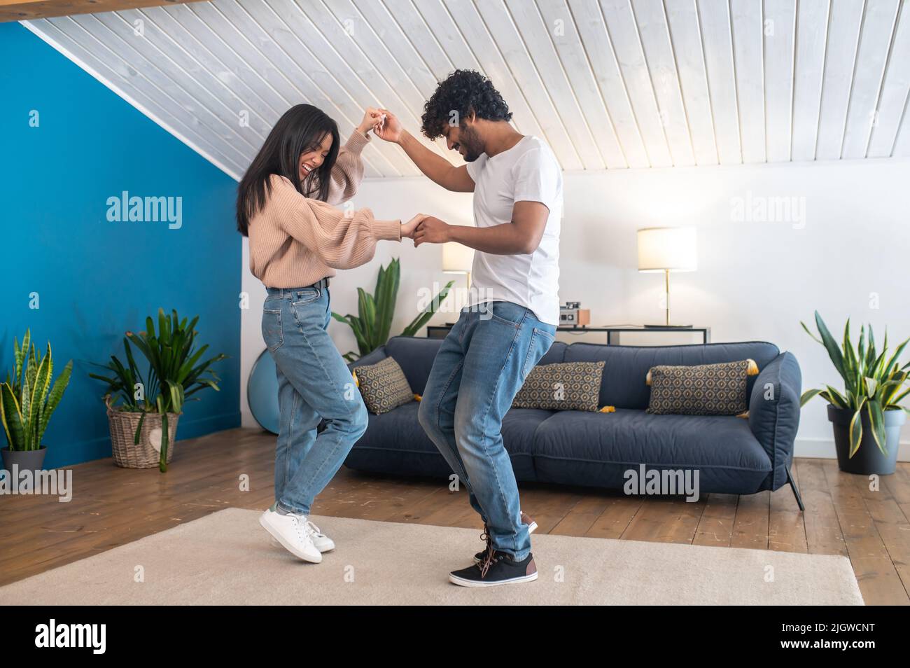 Cute young couple looking happy while dancing Stock Photo - Alamy