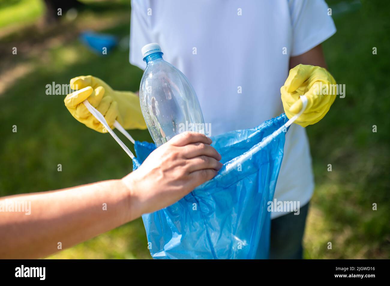 Someone helping a curly-haired teen to gather garbage Stock Photo - Alamy