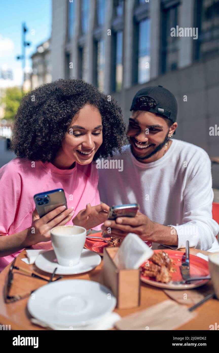Two young people watching something on the phone and smiling Stock ...