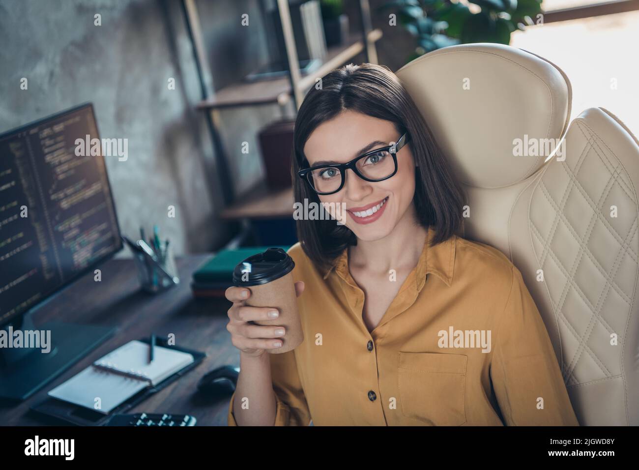 Portrait of positive pretty web designer sitting chair hold fresh ...