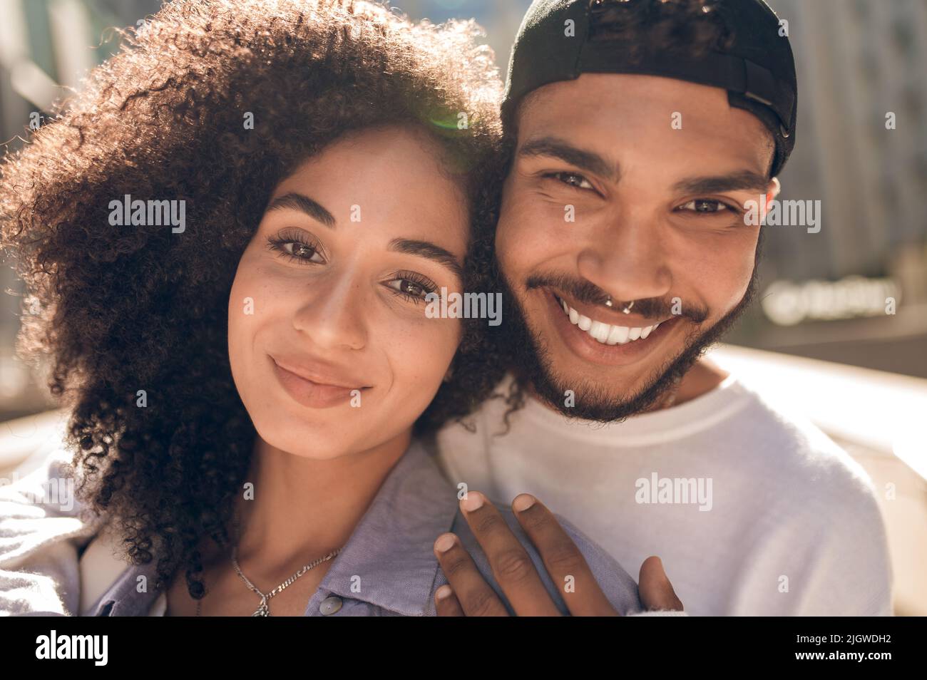Lovely young couple in sunlight looking happy Stock Photo - Alamy