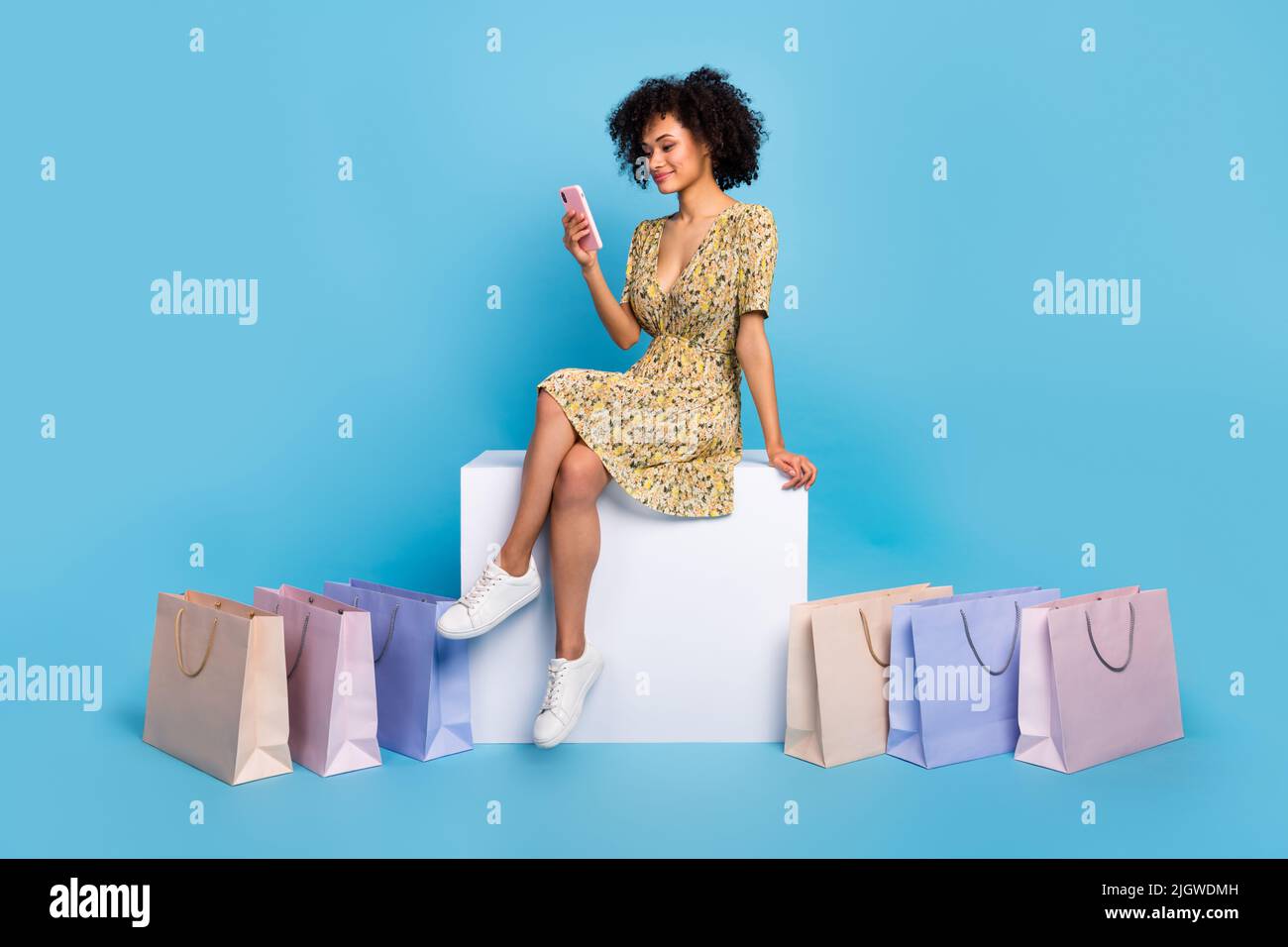 Photo of pretty shiny lady dressed print outfit sitting cube chair ...