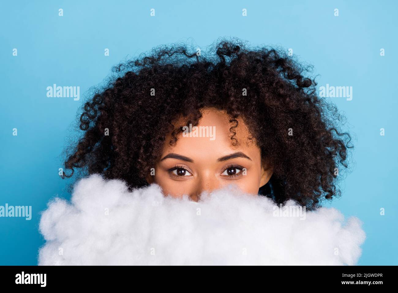 Portrait of attractive funny girly girl hhiding face behind white cloud ...