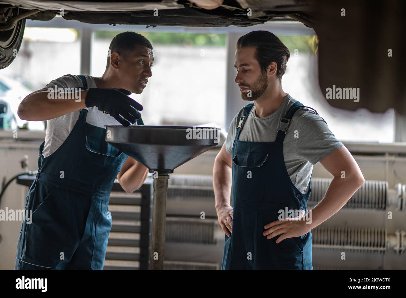 Two auto workshop workers repairing the customer car Stock Photo - Alamy