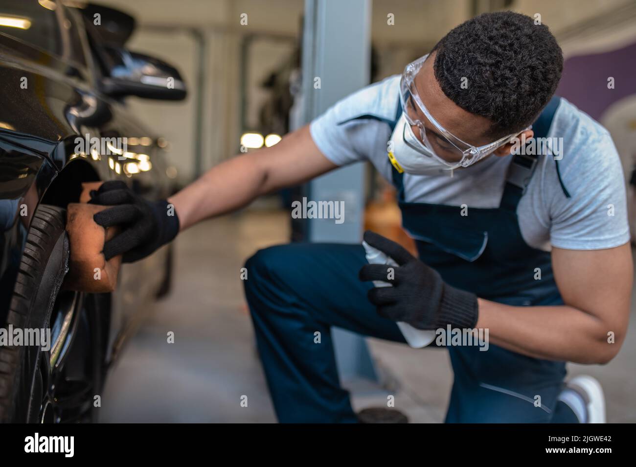Auto detailer buffing the car wheel with gloss Stock Photo - Alamy