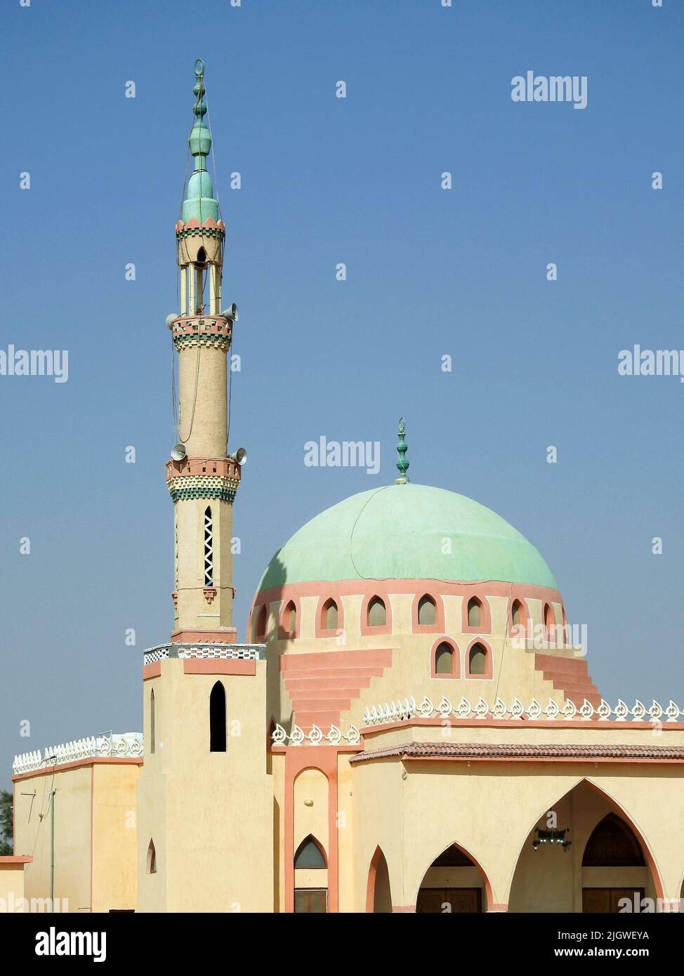 An Islamic mosque with a blue clear sunny summer sky with a green dome ...