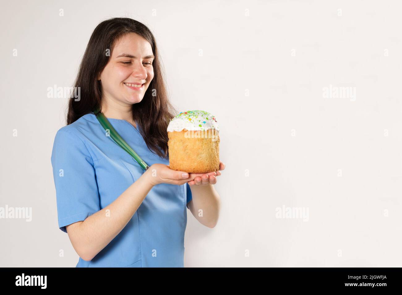 The doctor holds an Easter cake and smiles, a place for text. Medical ...
