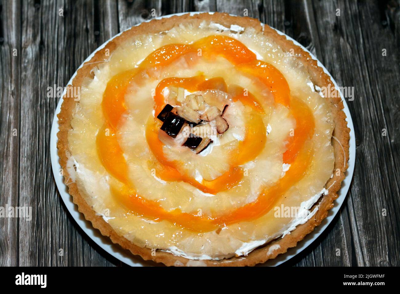 A tropical fruit tart cake with fresh pieces of apple, slices of fresh ...