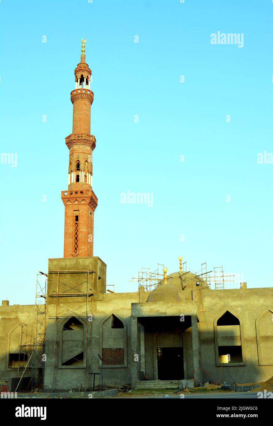 A new mosque under construction against the sunny blue sky with the ...