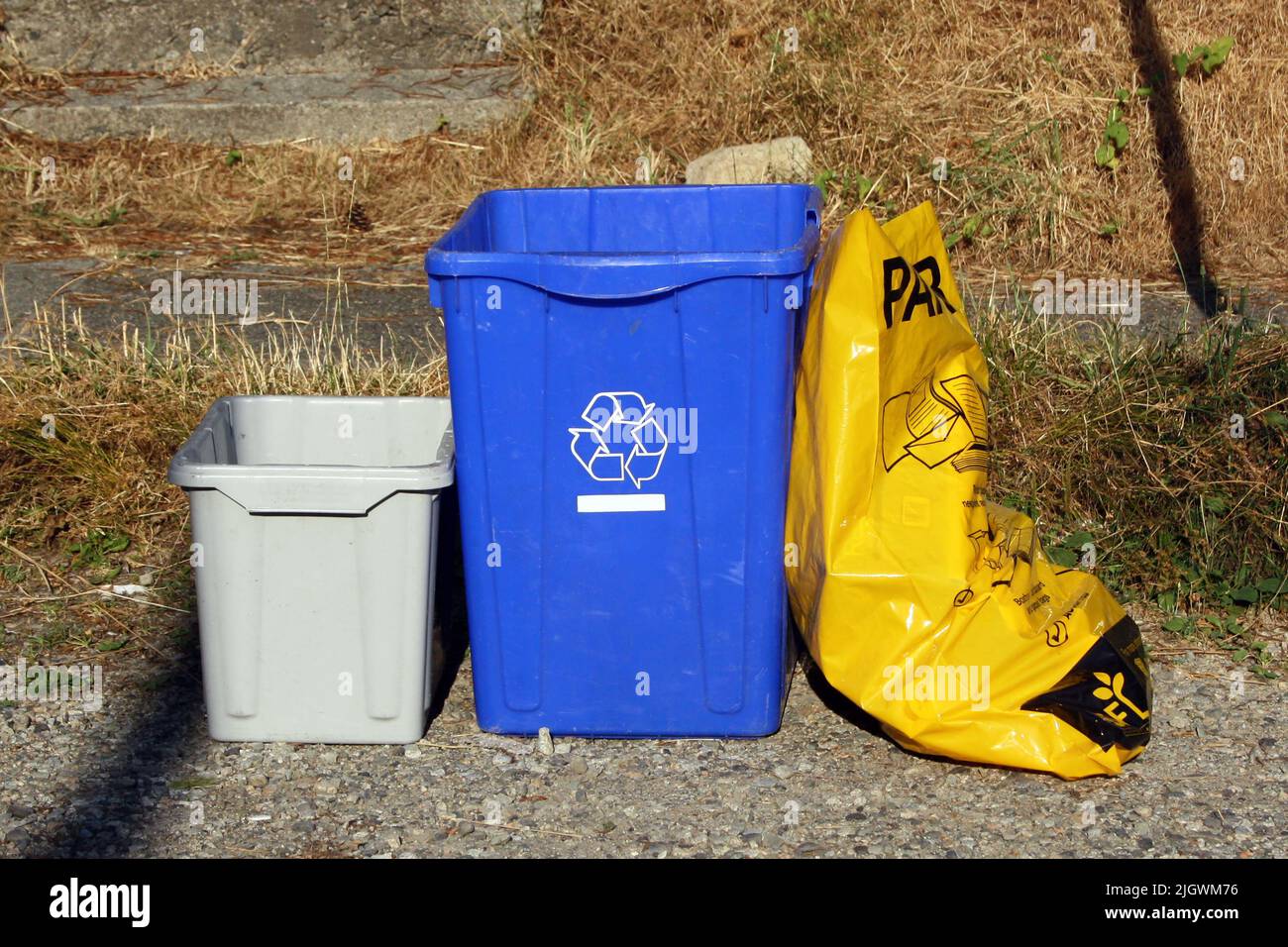a bag and two recycling plastic containers on the ground Stock Photo ...