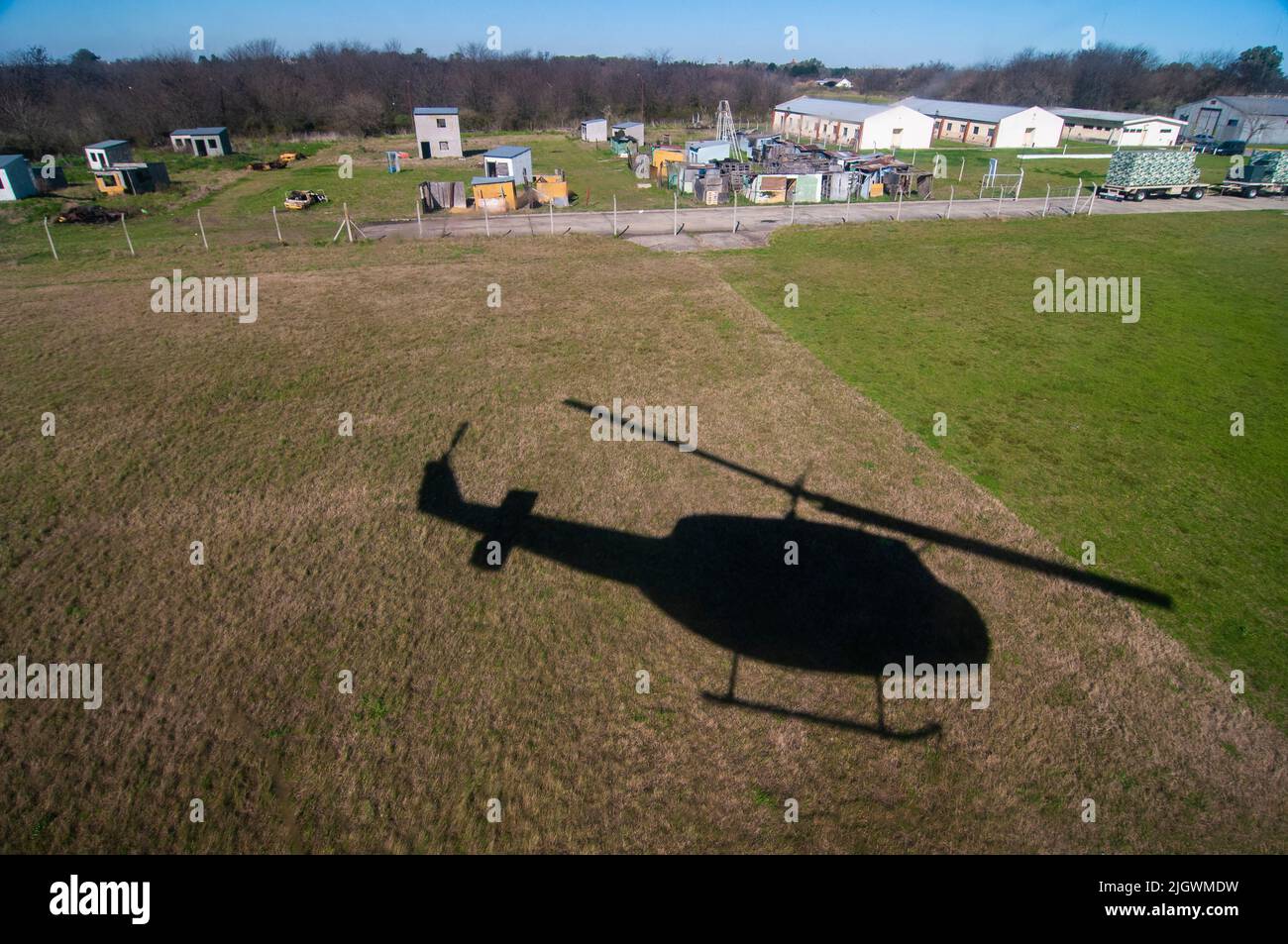 A high angle of a helicopter shadow on a green field during a hostile ...