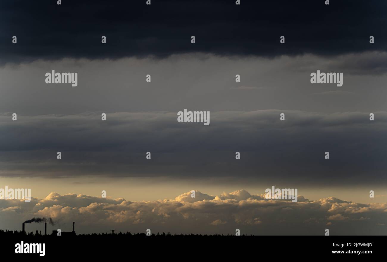 A dramatic shot of three layers of clouds black layer above and a white ...