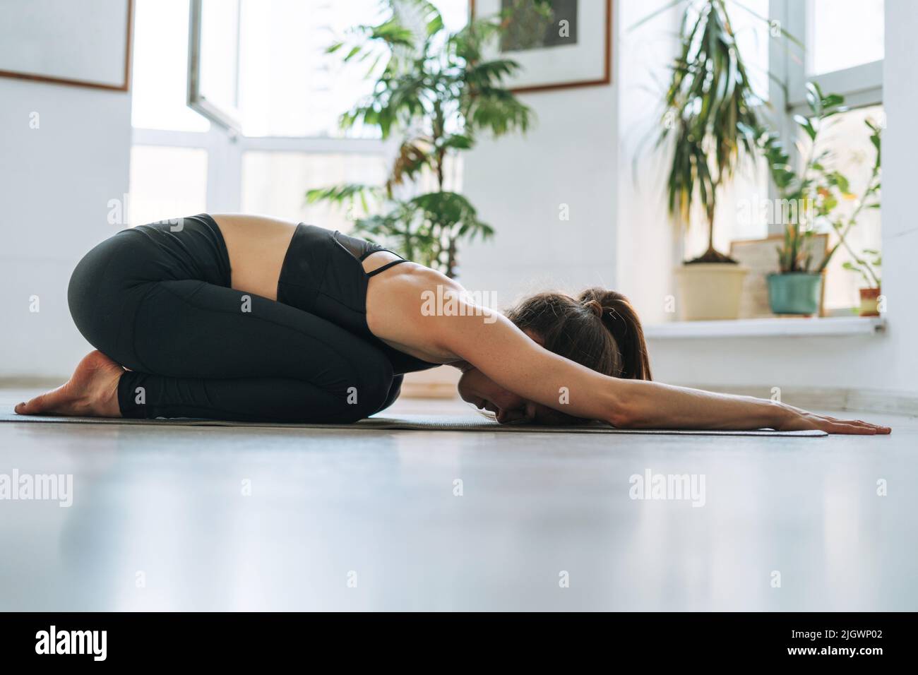 Young fit woman practice yoga doing asana in light yoga studio with ...