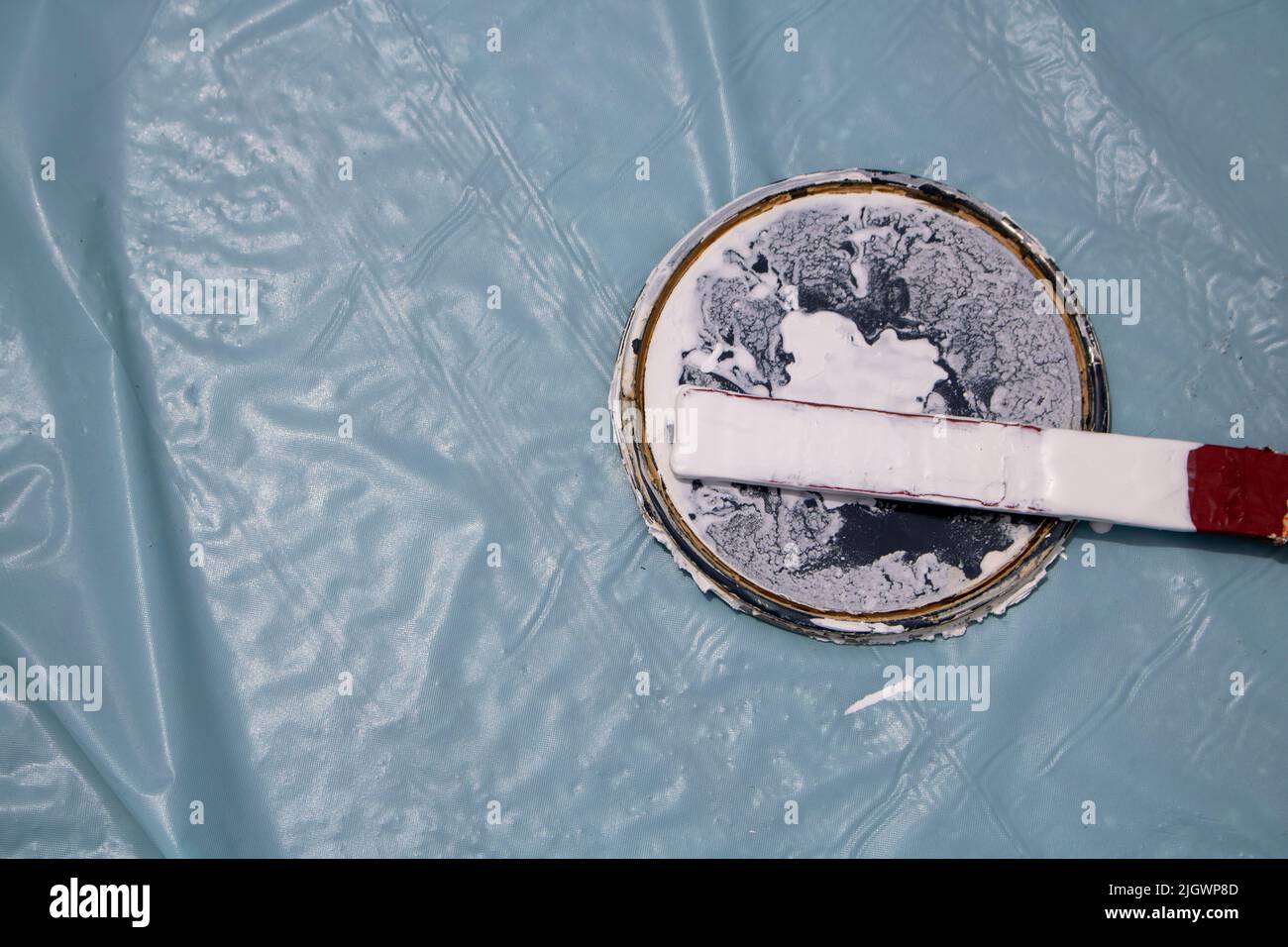 Mixing painting stick on gallon paint can cover on a protection ground ...