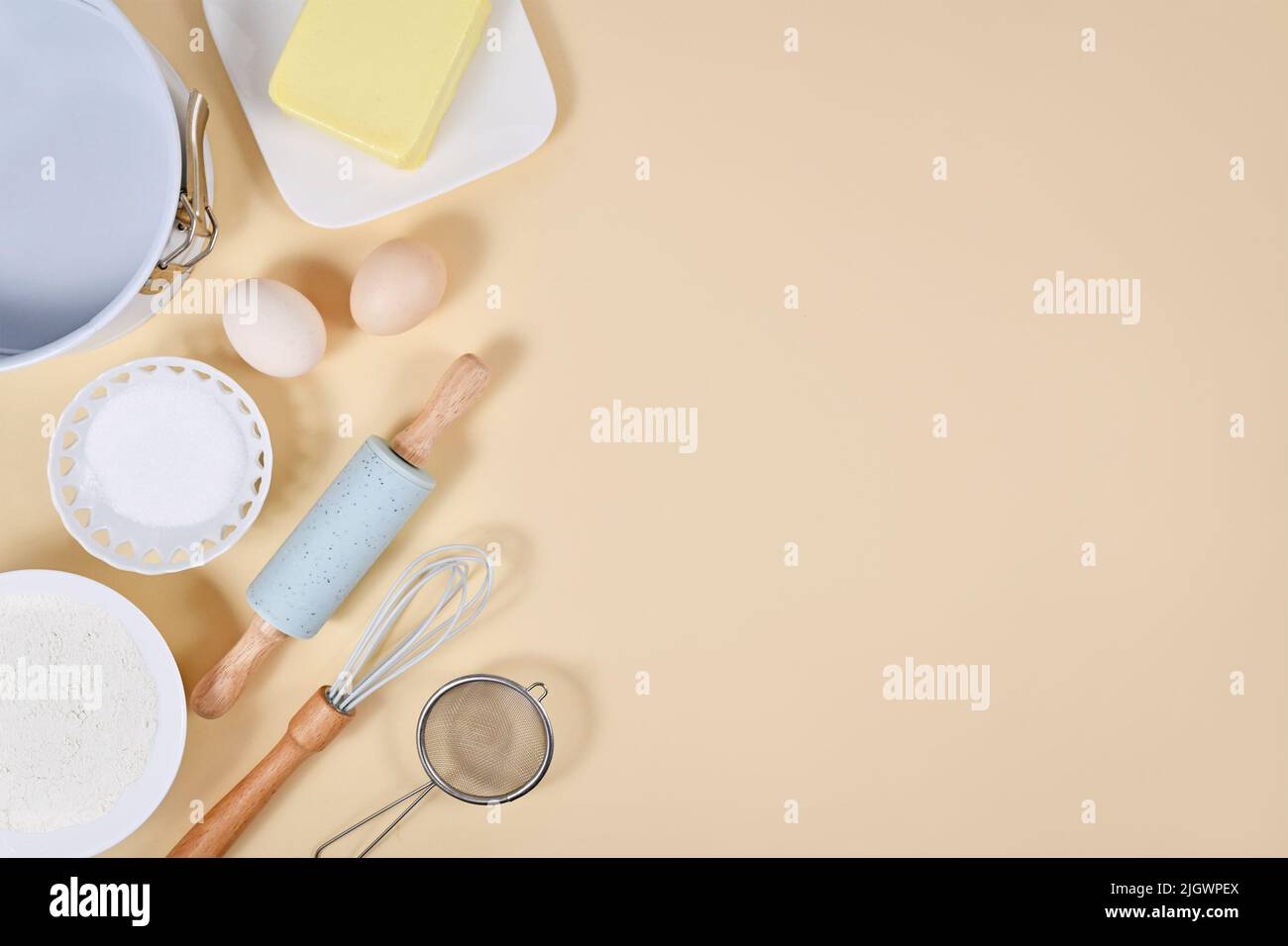 Cake dough ingredients and baking tools on beige background with copy ...