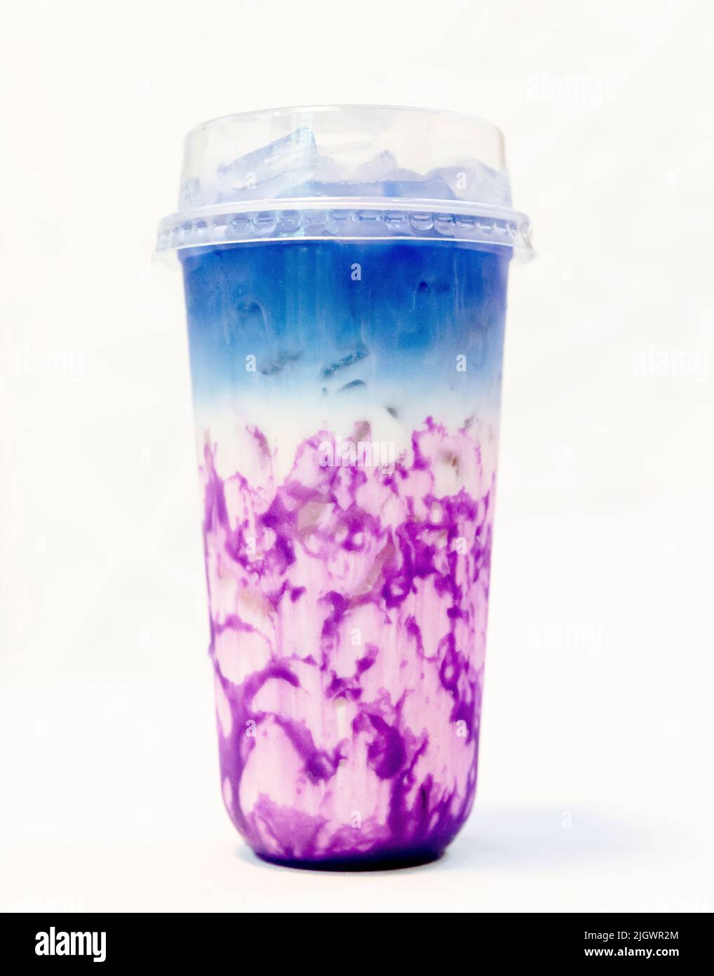 A vertical closeup of a purple and blue drink in a plastic cup isolated ...