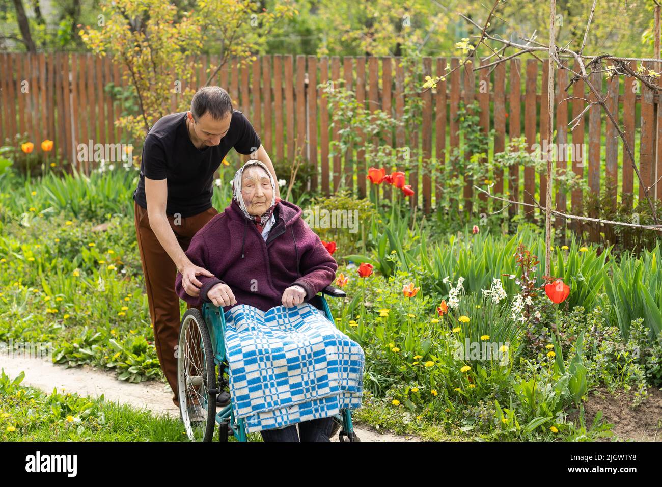 Senior care assistant with very old disabled woman in nursing home ...