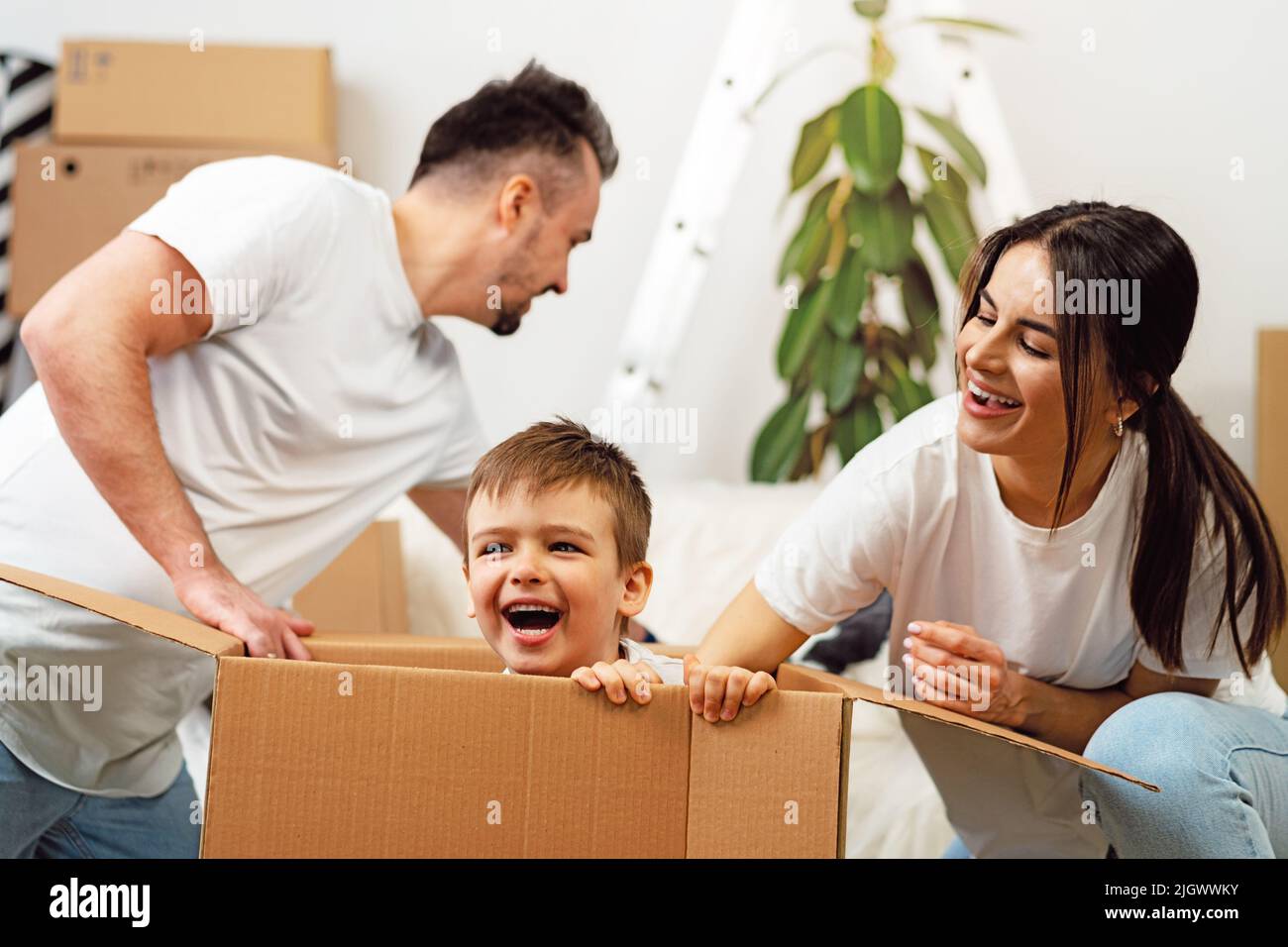 Parents and son packing boxes and moving into a new home Stock Photo ...