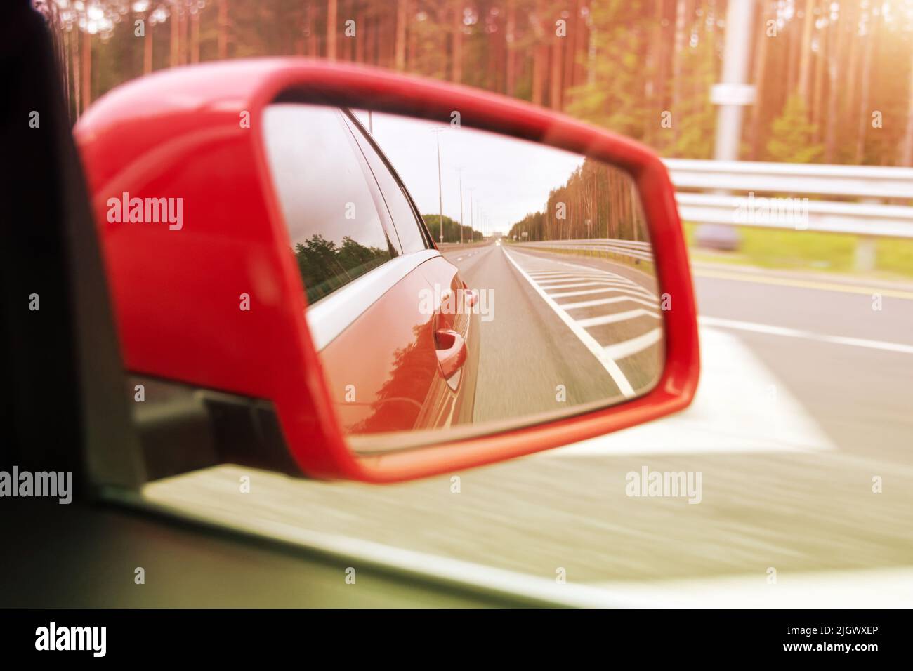 Side rearview mirror of a red car, roadside and highway reflection ...