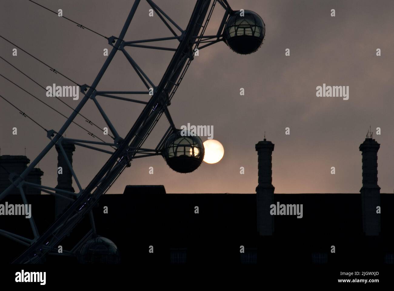 London Eye sunrise with sun partially eclipsed behind one capsule Stock ...