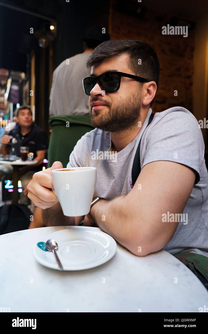 Handsome man drinking coffee in outdoor cafe Stock Photo - Alamy