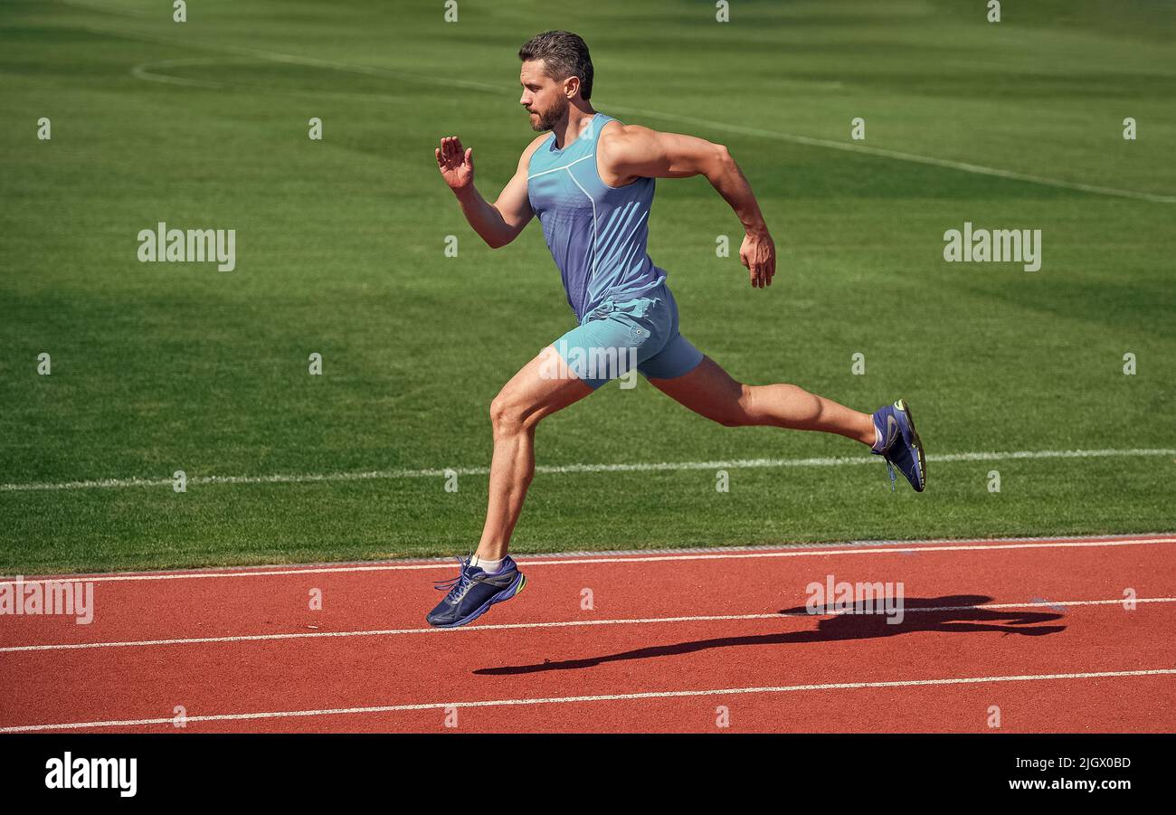 athletic muscular man running in sportswear on stadium track, stamina ...