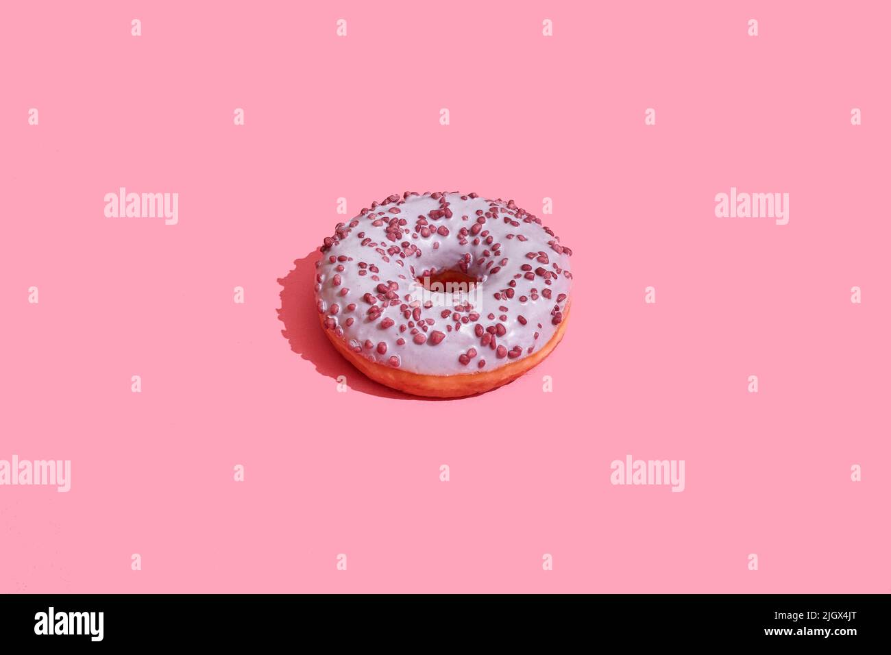 Food design. Close up high quality image of pink glazed donut on coral ...