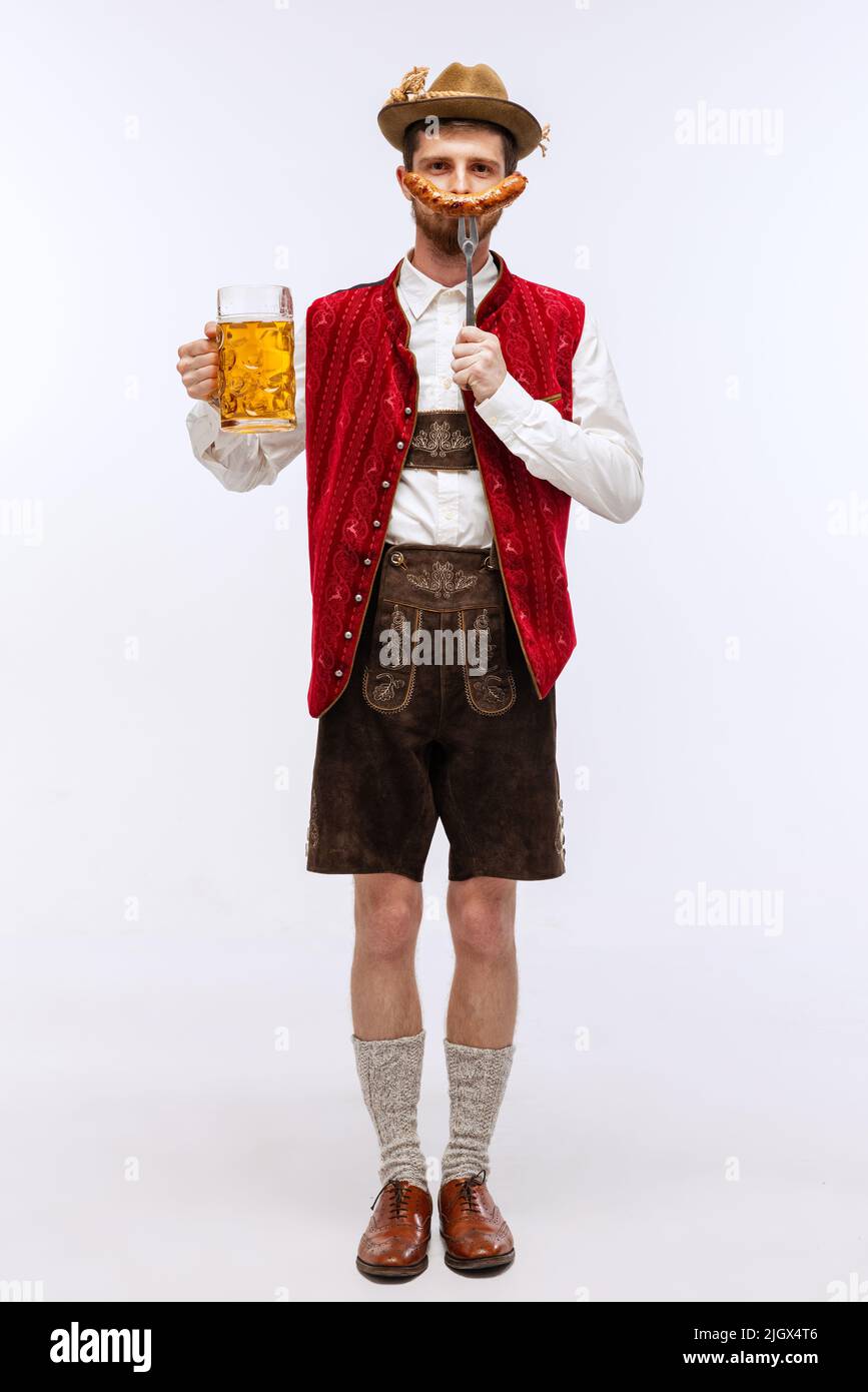 Young expressive man in hat, wearing fest traditional Bavarian or ...