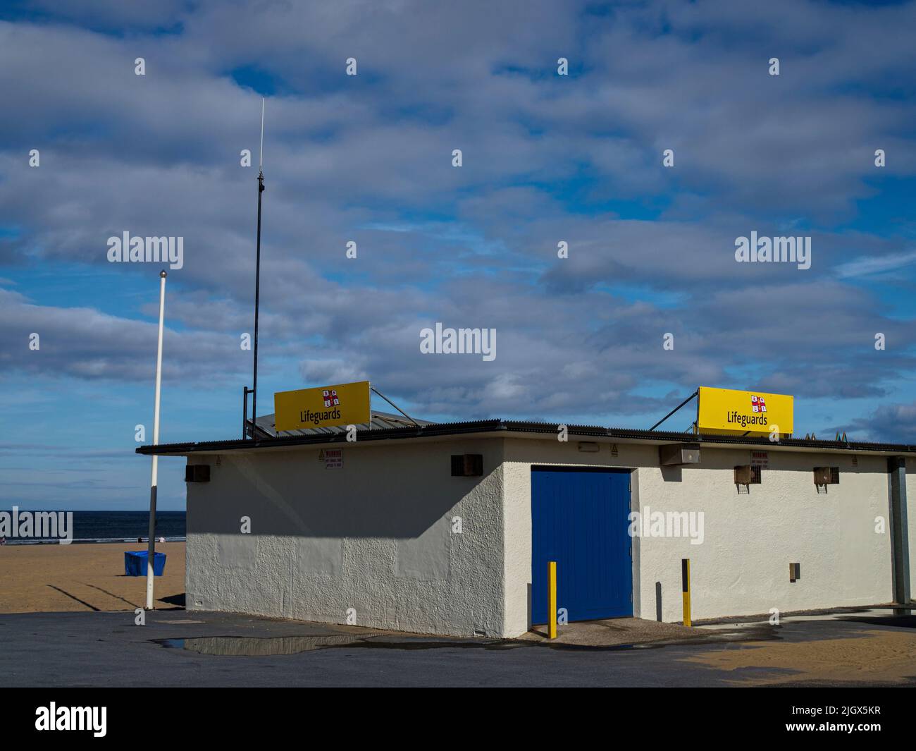 An exterior view of a building with two "Lifeguards" billboards on the ...