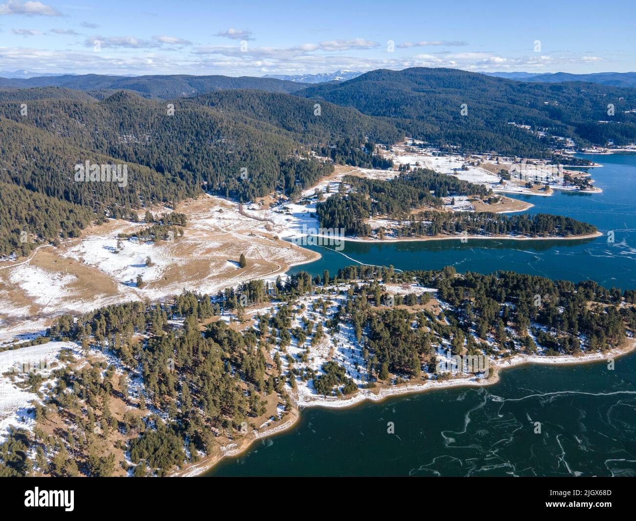 Aerial winter view of Dospat Reservoir covered with ice, Smolyan Region ...