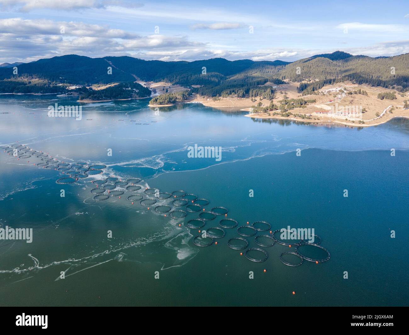 Aerial winter view of Dospat Reservoir covered with ice, Smolyan Region ...