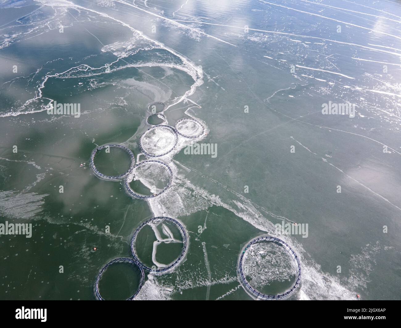 Aerial winter view of Dospat Reservoir covered with ice, Smolyan Region ...