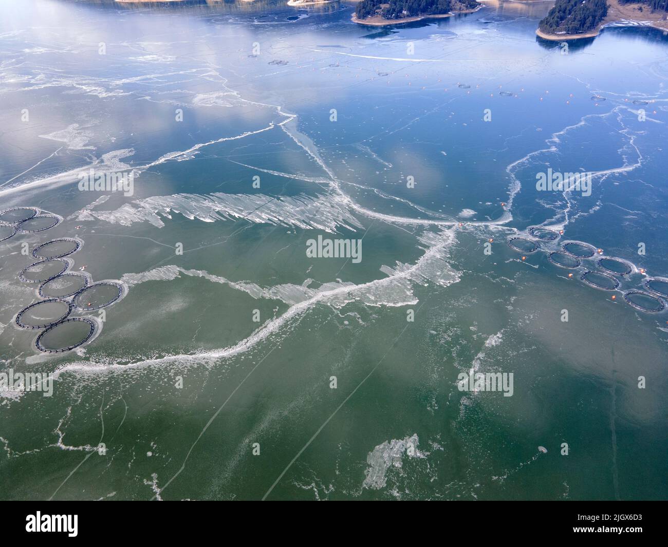 Aerial winter view of Dospat Reservoir covered with ice, Smolyan Region ...