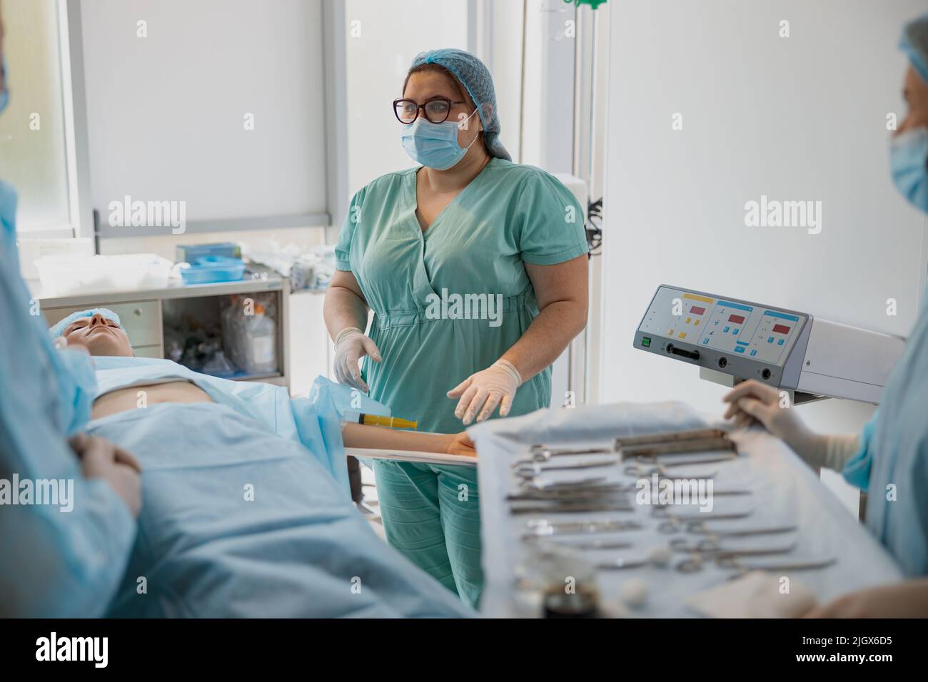 Nurse assisting doctors during surgery in operation room of modern ...