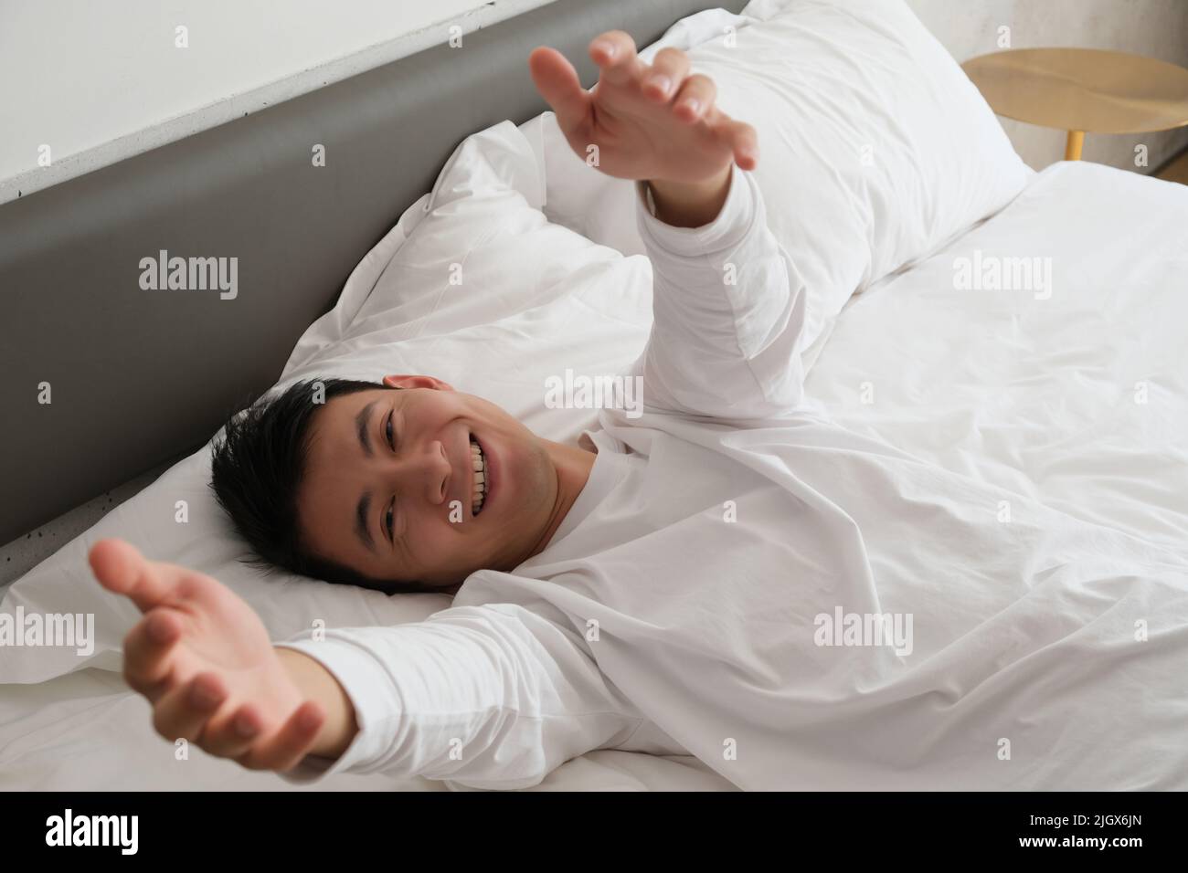 handsome Asian young man need a hug on bed in morning Stock Photo - Alamy