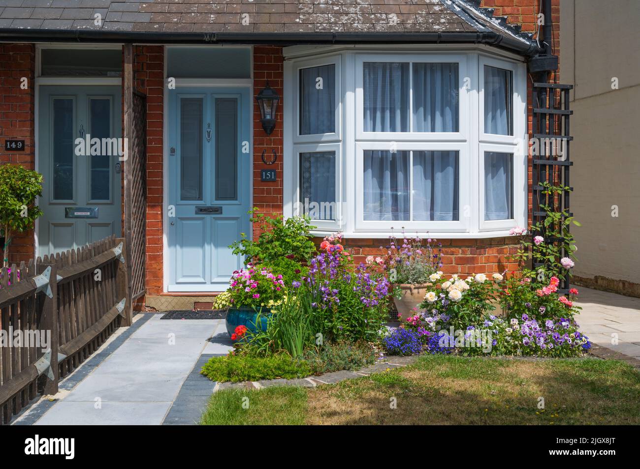 Suburban Victorian end terrace house in summertime with flower filled ...