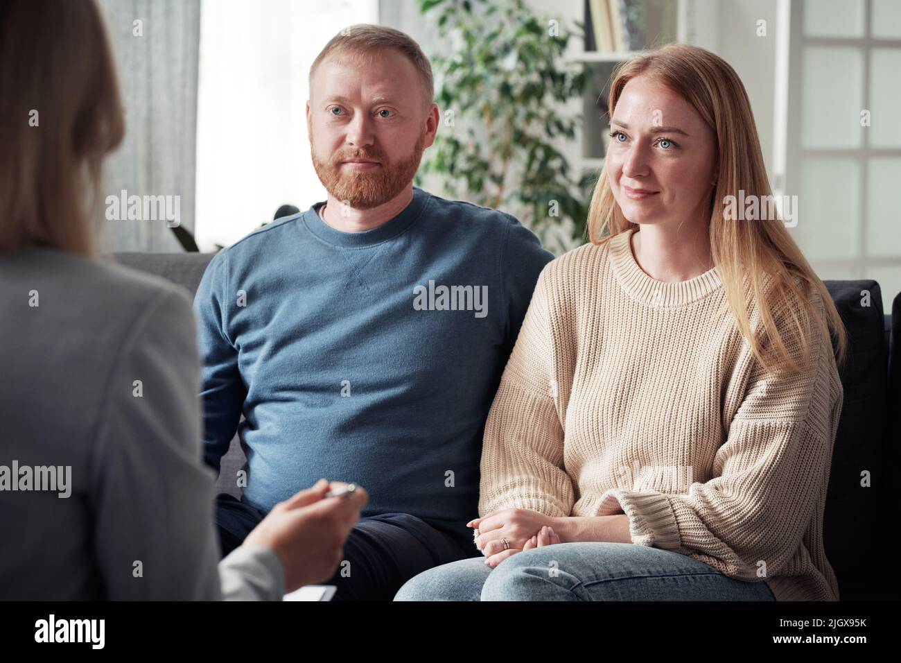 Young foster couple listening to briefing of social worker before ...