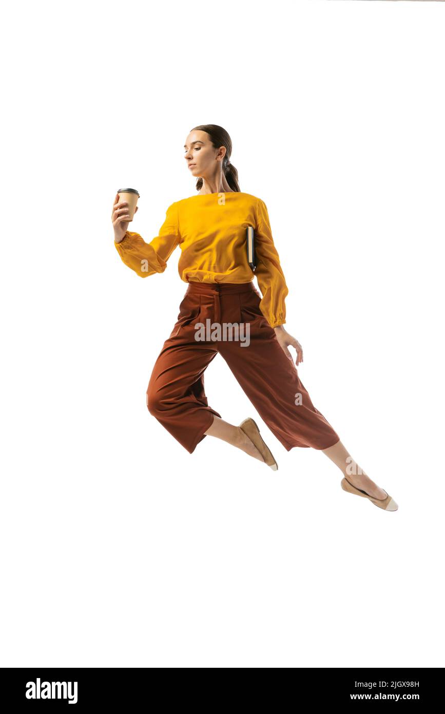 Energetic young girl jumping, flying isolated on white background ...