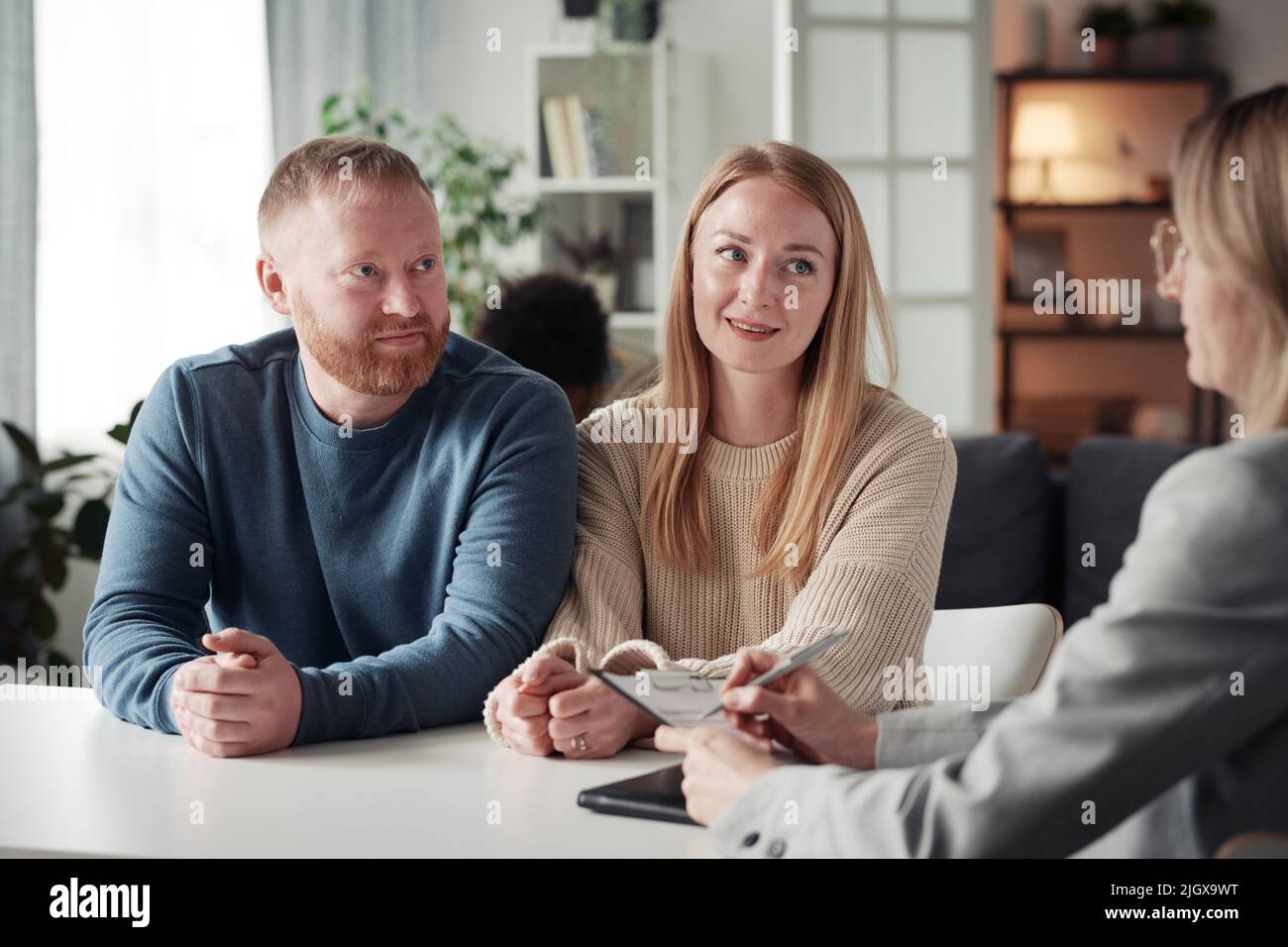 Young couple having an interview with social worker before adoption of ...