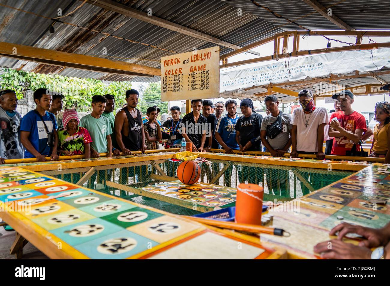 Locals throw a basketball and place bets as a part of a local roulette ...