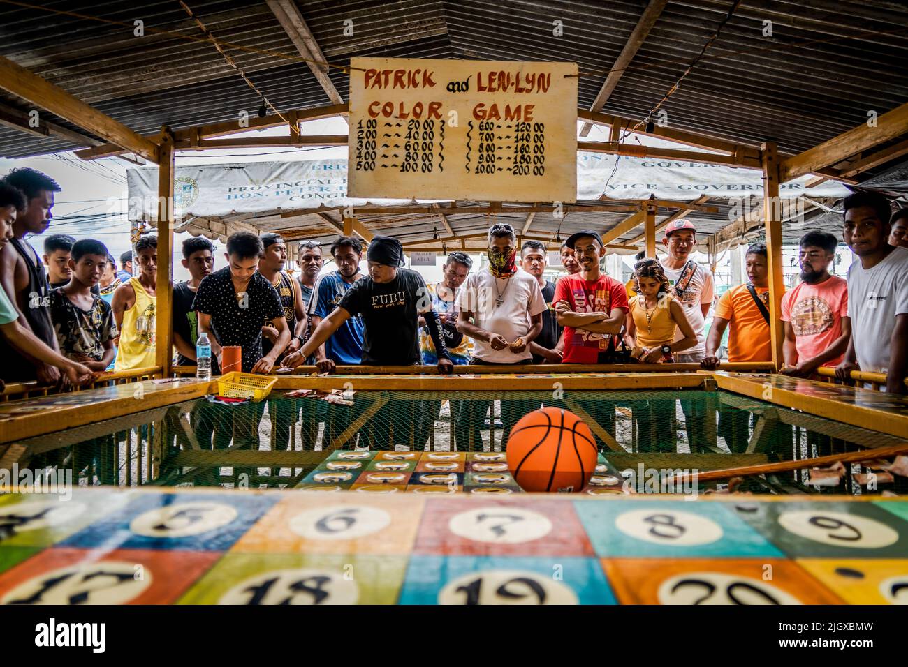 Locals throw a basketball and place bets as a part of a local roulette ...