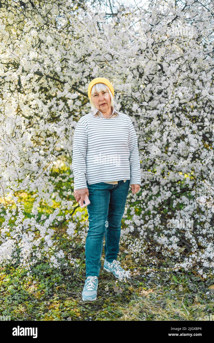 Portrait of a happy beautiful blonde haired senior woman in stylish ...