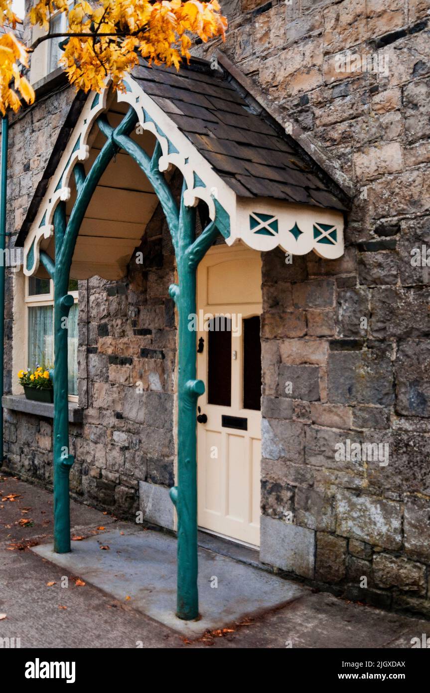 Tree branch columns and carved bargeboards on stone terraced cottages ...