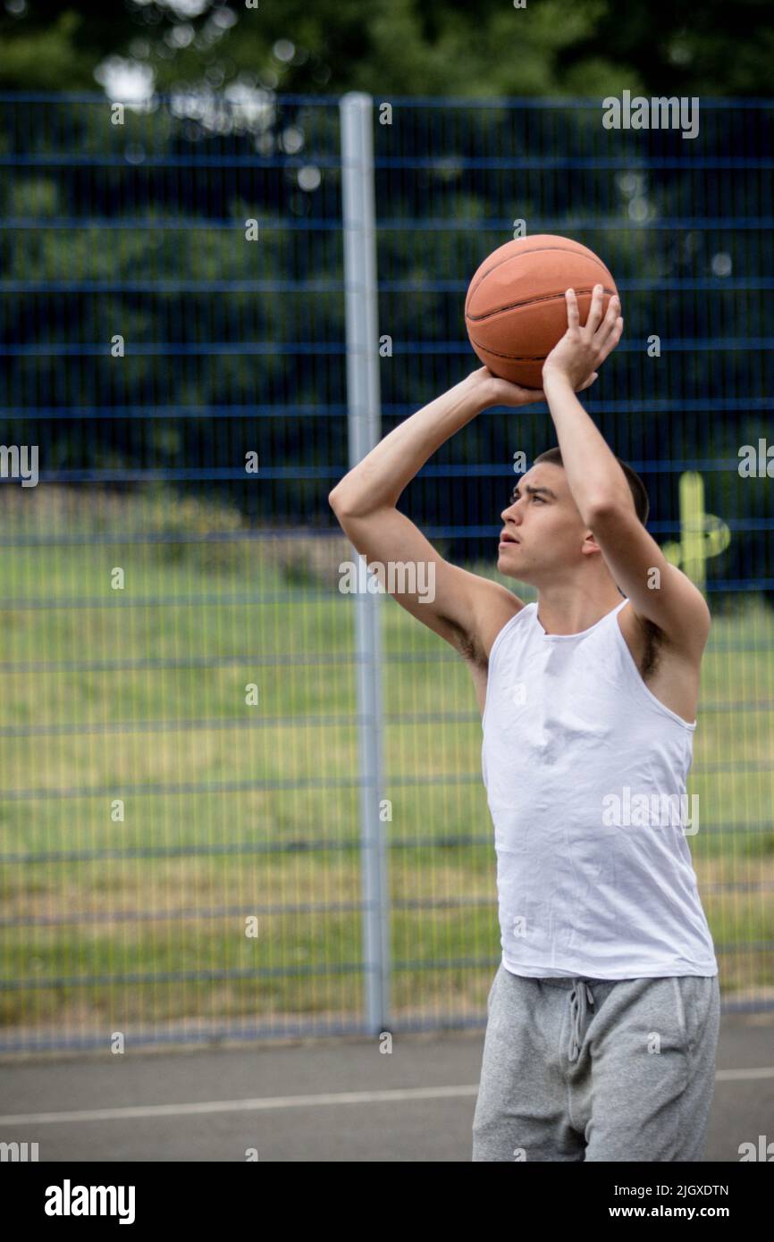 A Nineteen Year Old Teenage Boy Shooting A Hoop in A Basketball Court ...
