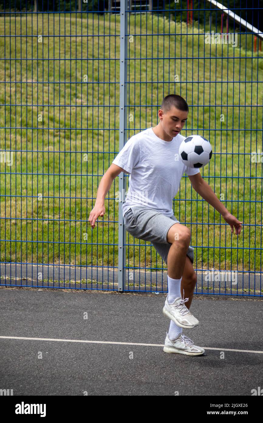 A Nineteen Year Old Teenage Boy Playing Football in A Public Park Stock ...