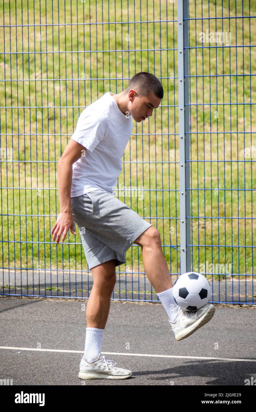A Nineteen Year Old Teenage Boy Playing Football in A Public Park Stock ...