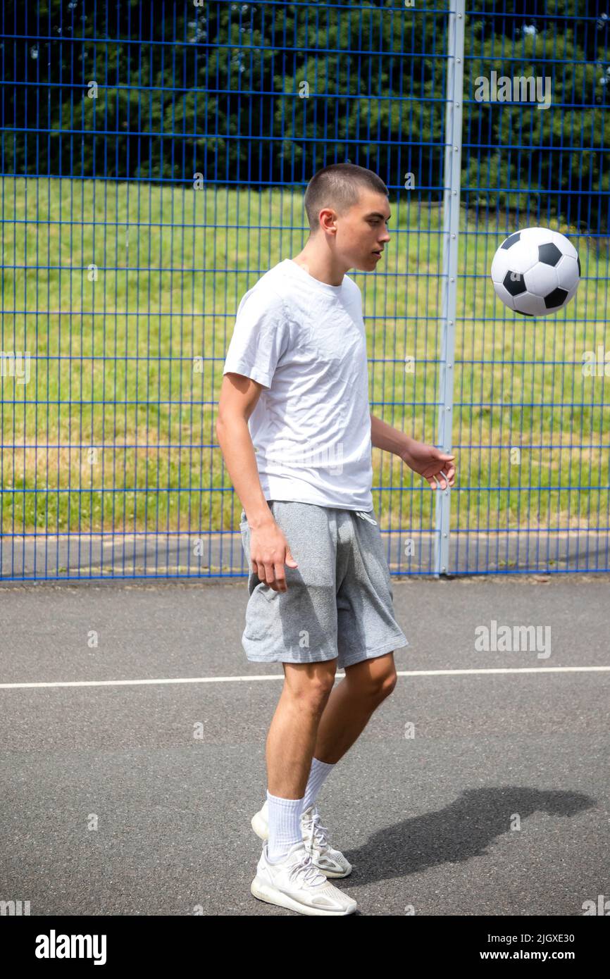 A Nineteen Year Old Teenage Boy Playing Football in A Public Park Stock ...
